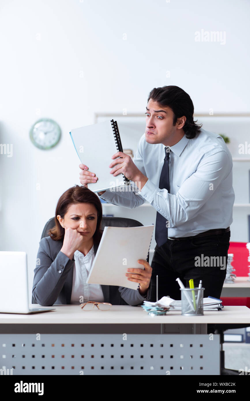Old female boss and young male employee in the office Stock Photo - Alamy