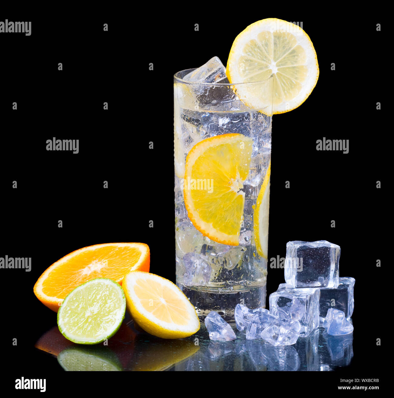 Citrus Ice Water. Citrus ice water glass and citrus fruits over black ...