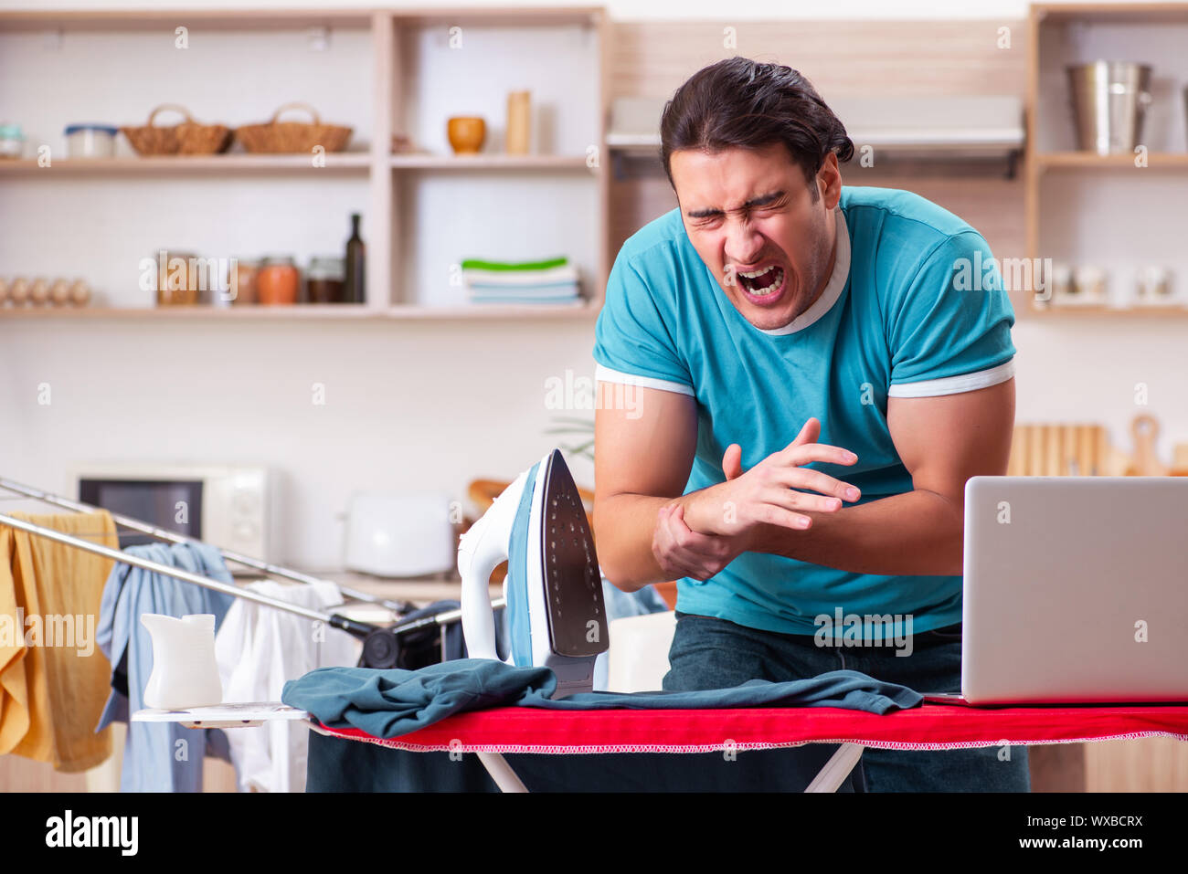 Young man husband doing clothing ironing at home Stock Photo - Alamy