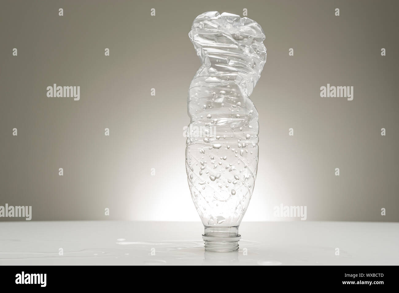Empty recyclable plastic water bottle covered in water droplets and ...