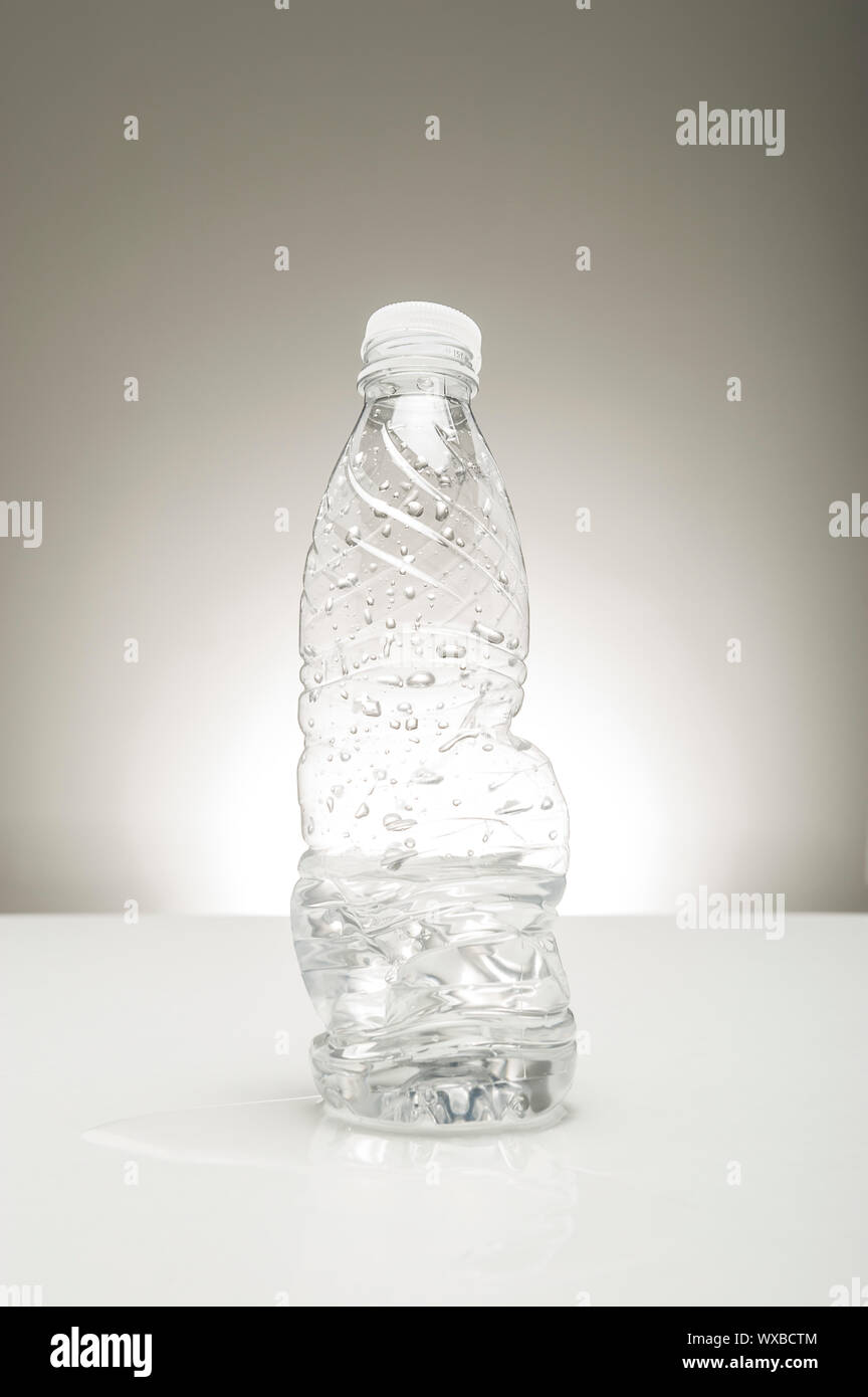 Half consumed bottle of water in a clear transparent bottle that has ...