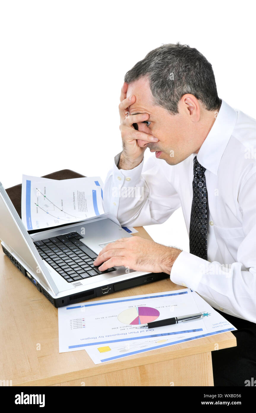 Stressed businessman sitting at his desk isolated on white background ...