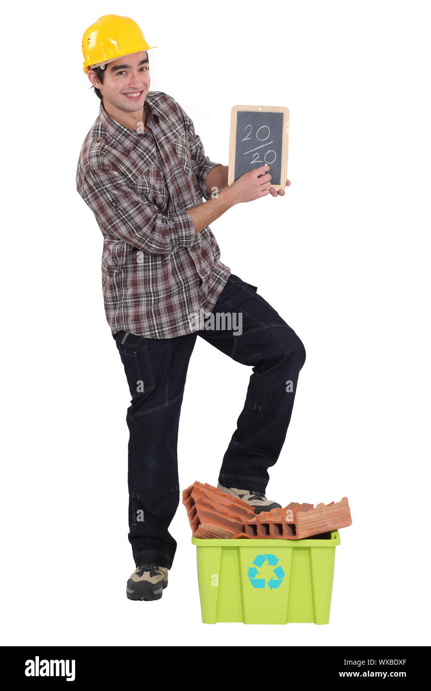 Builder stood with chalk board and recyclable waste material Stock ...