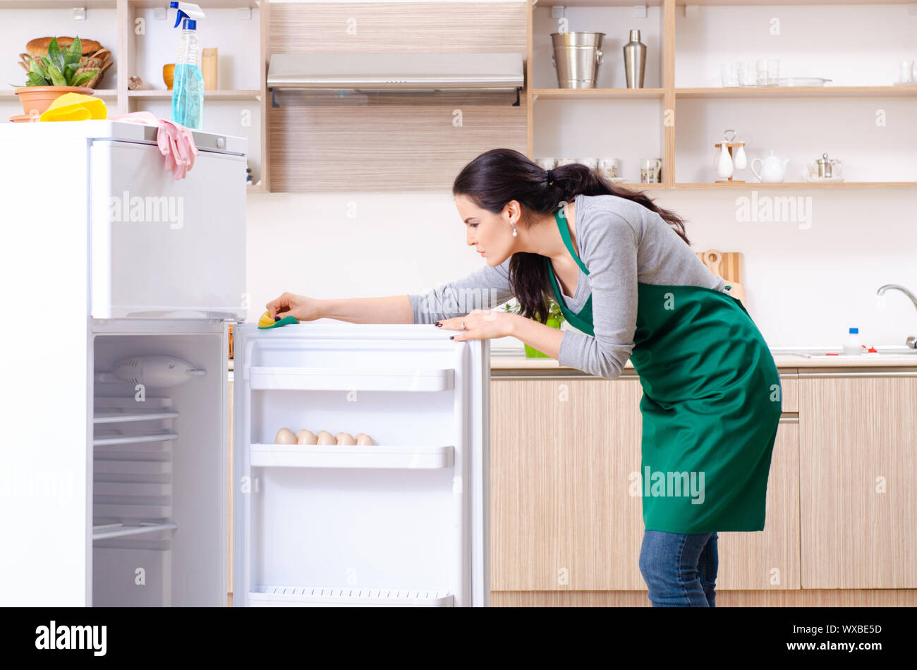 Young woman cleaning fridge in hygiene concept Stock Photo - Alamy