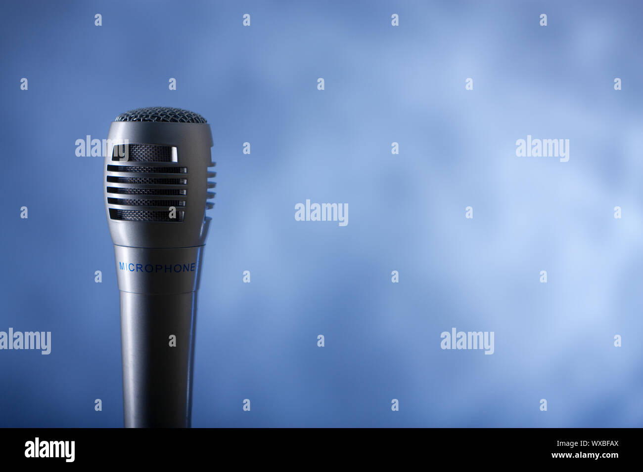 the single microphone on the blue background Stock Photo - Alamy