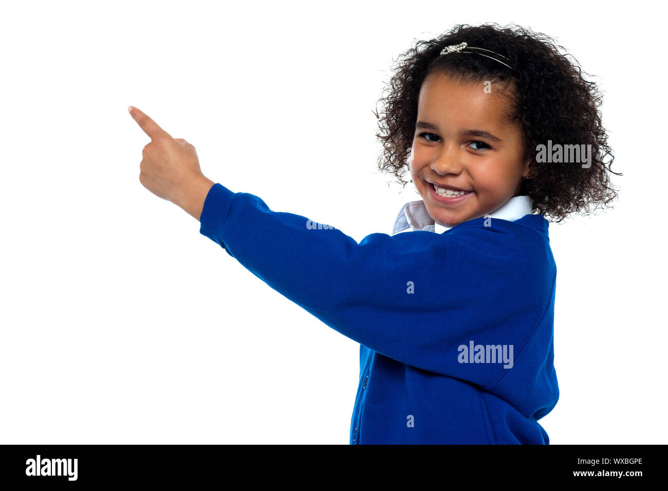 Adorable African kid pointing at copy space area while facing the ...