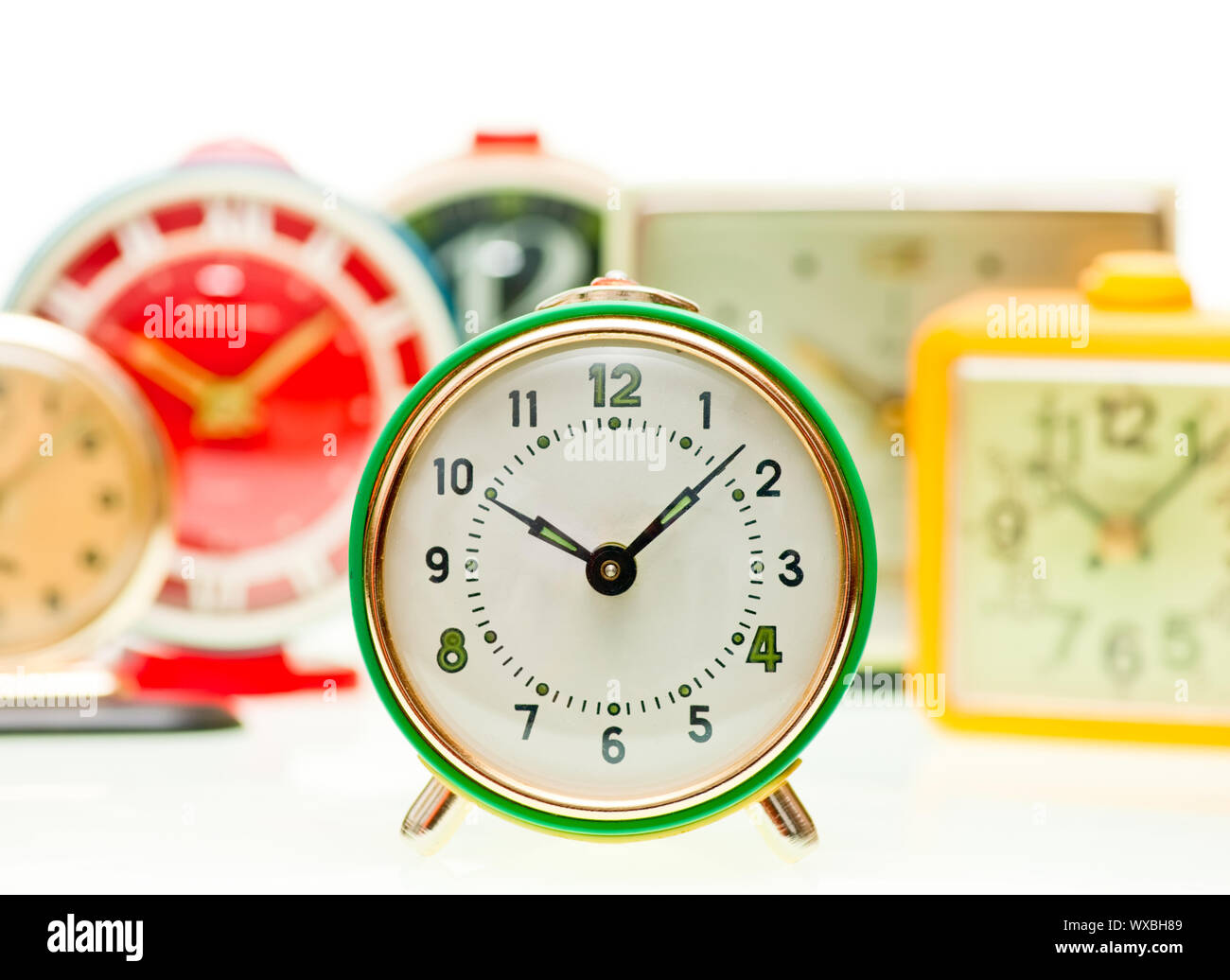Vintage mechanical wind-up alarm clocks on white background, shallow ...