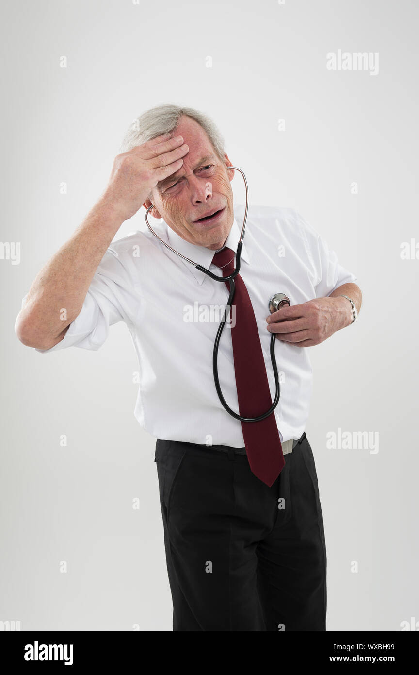 Old man, who is feeling unwell, is trying to diagnose his condition his ...