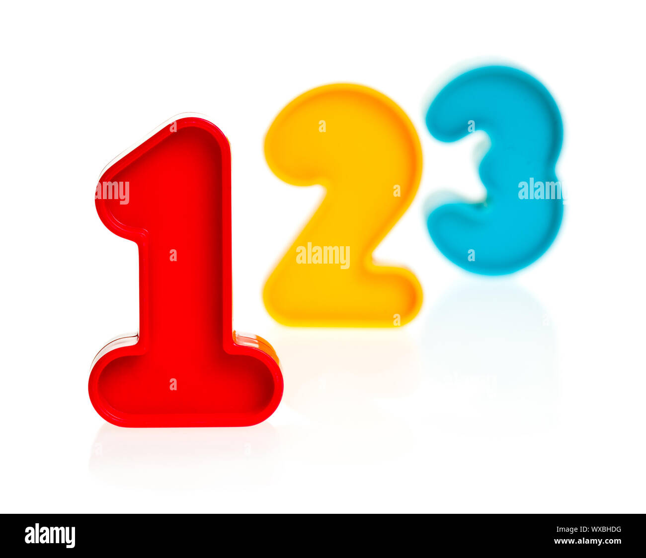Colorful plastic numbers one two three on white background, focus on 1 ...