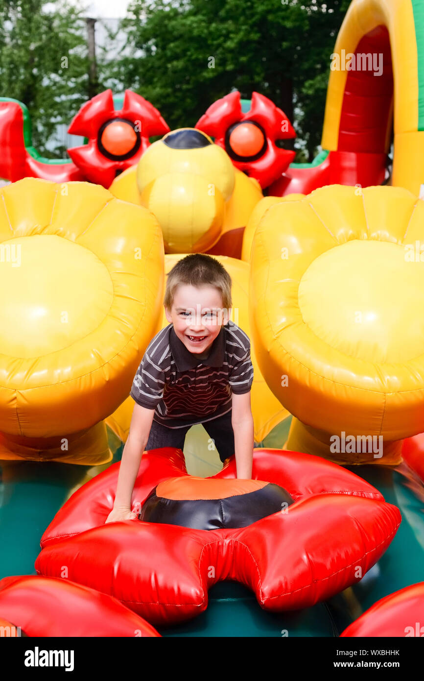 Young boy playing in inflatable playground Stock Photo - Alamy