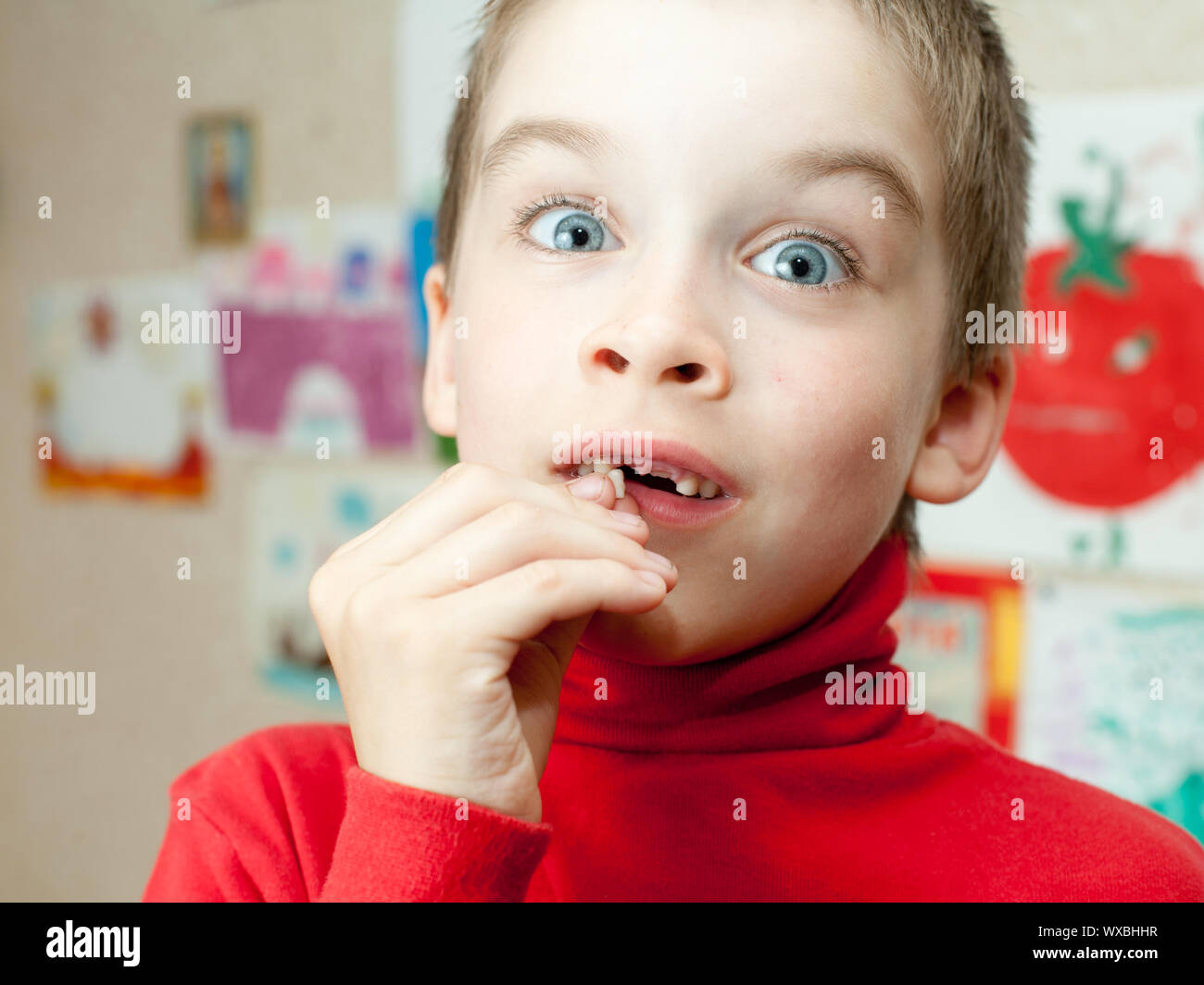 Boy holding lost deciduous teeth against his drawing on the wall Stock ...