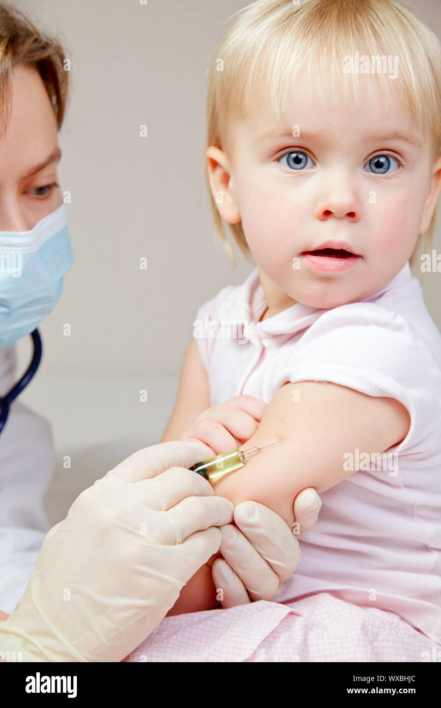 Doctor giving child intramuscular injection hi-res stock photography ...