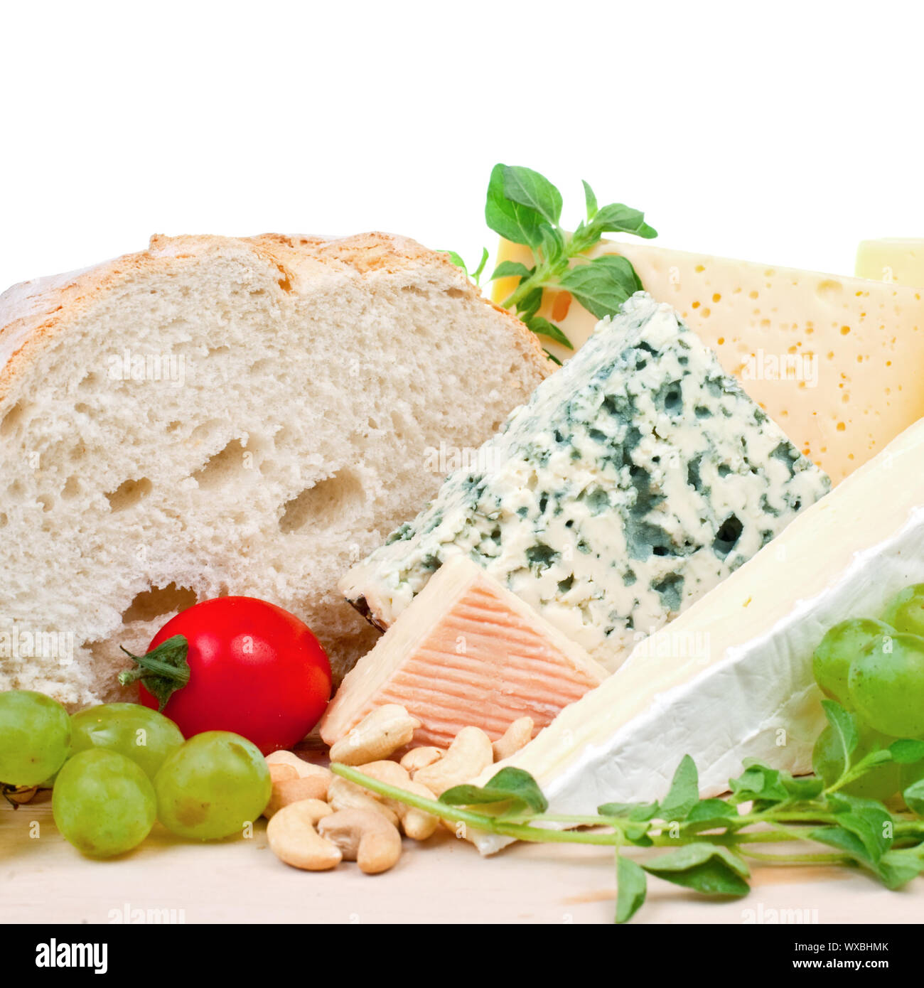 Various types of cheese and garnishes on wooden plate Stock Photo - Alamy