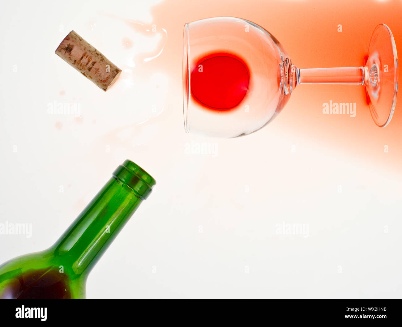 Bottle, cork and glass on red wine spill Stock Photo - Alamy