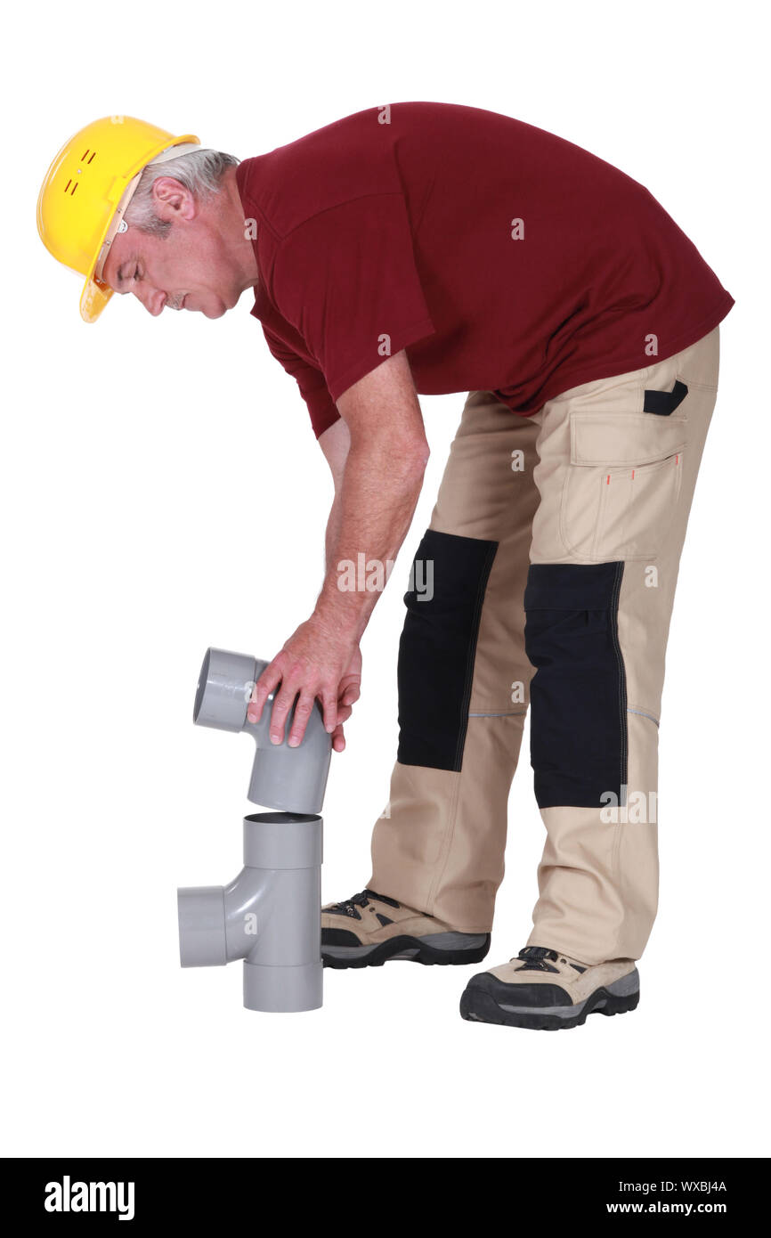 Old plumber connecting two pipes Stock Photo - Alamy
