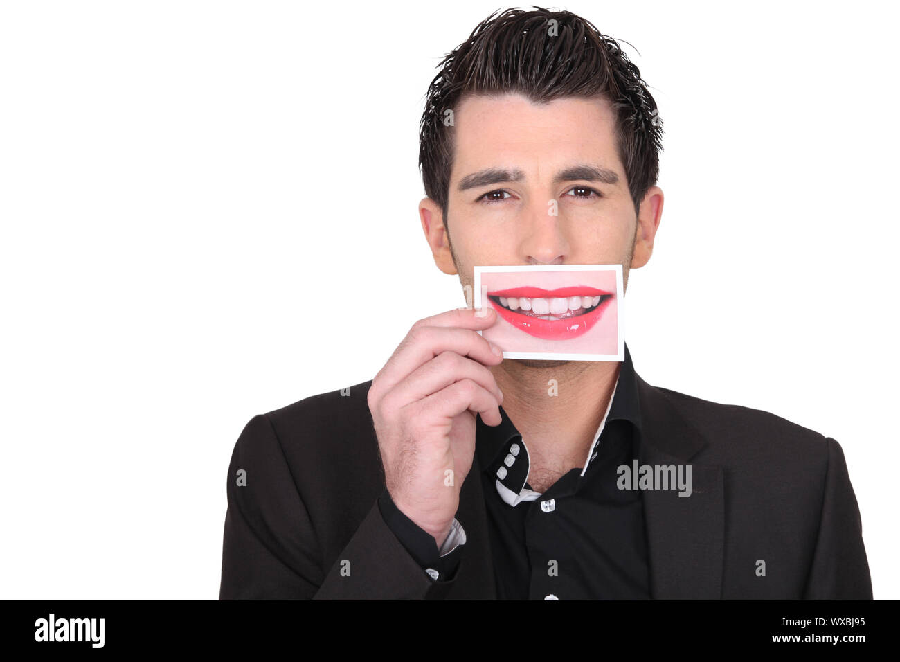Man in a suit holding a photo of lips to his mouth Stock Photo - Alamy