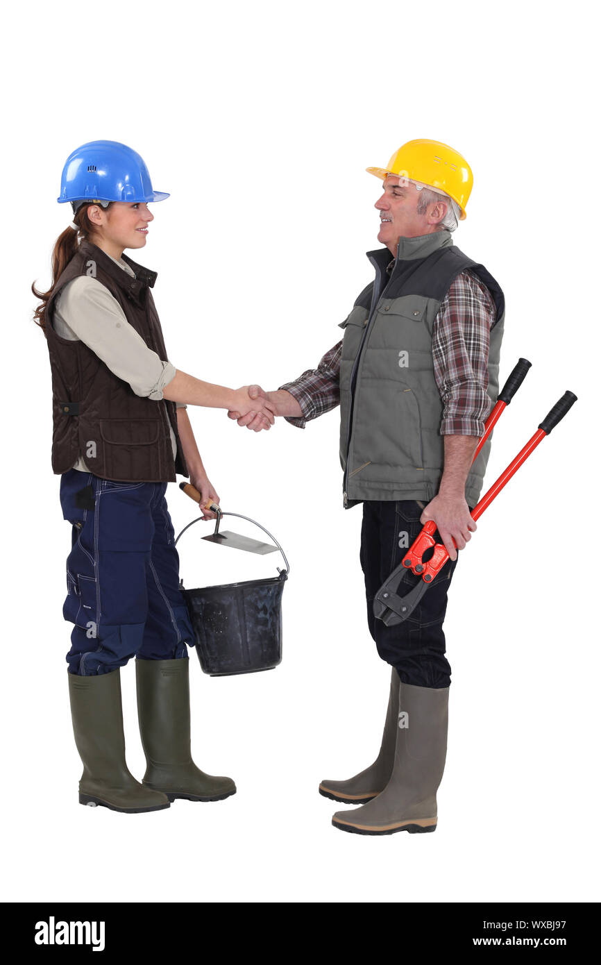 Construction workers handshaking, studio shot Stock Photo - Alamy