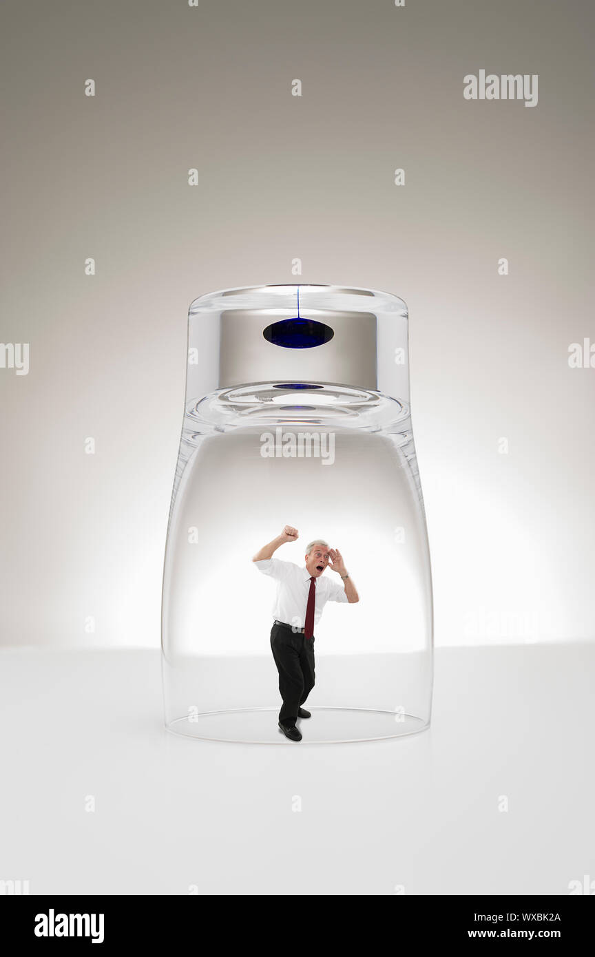 Conceptual studio image of a diminutive grey-haired senior business man ...