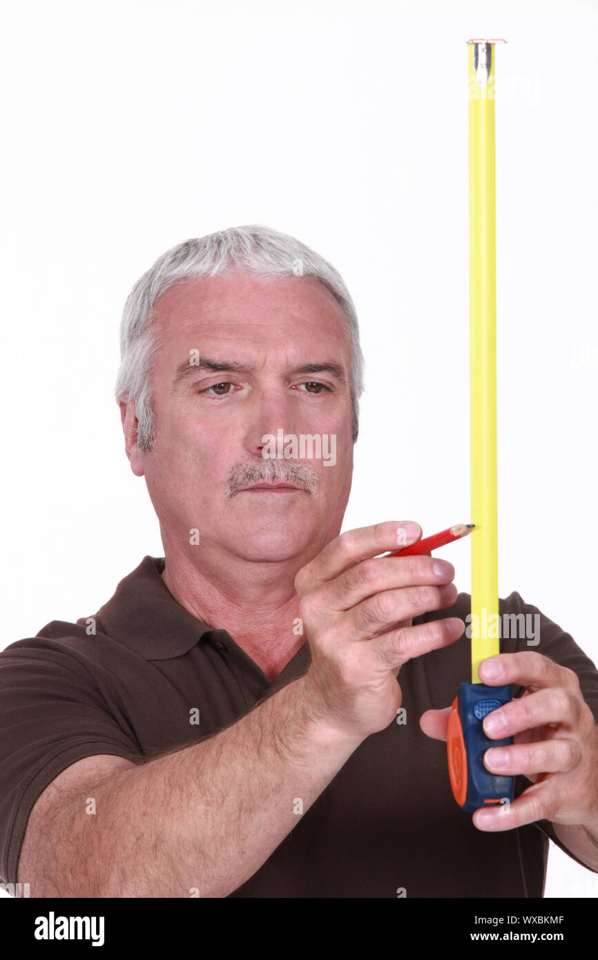 Man using tape measure and pencil Stock Photo - Alamy