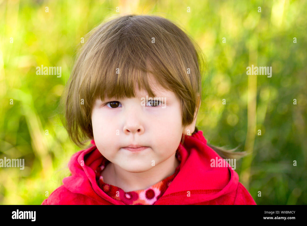 Portrait of little girl looking up at you Stock Photo - Alamy