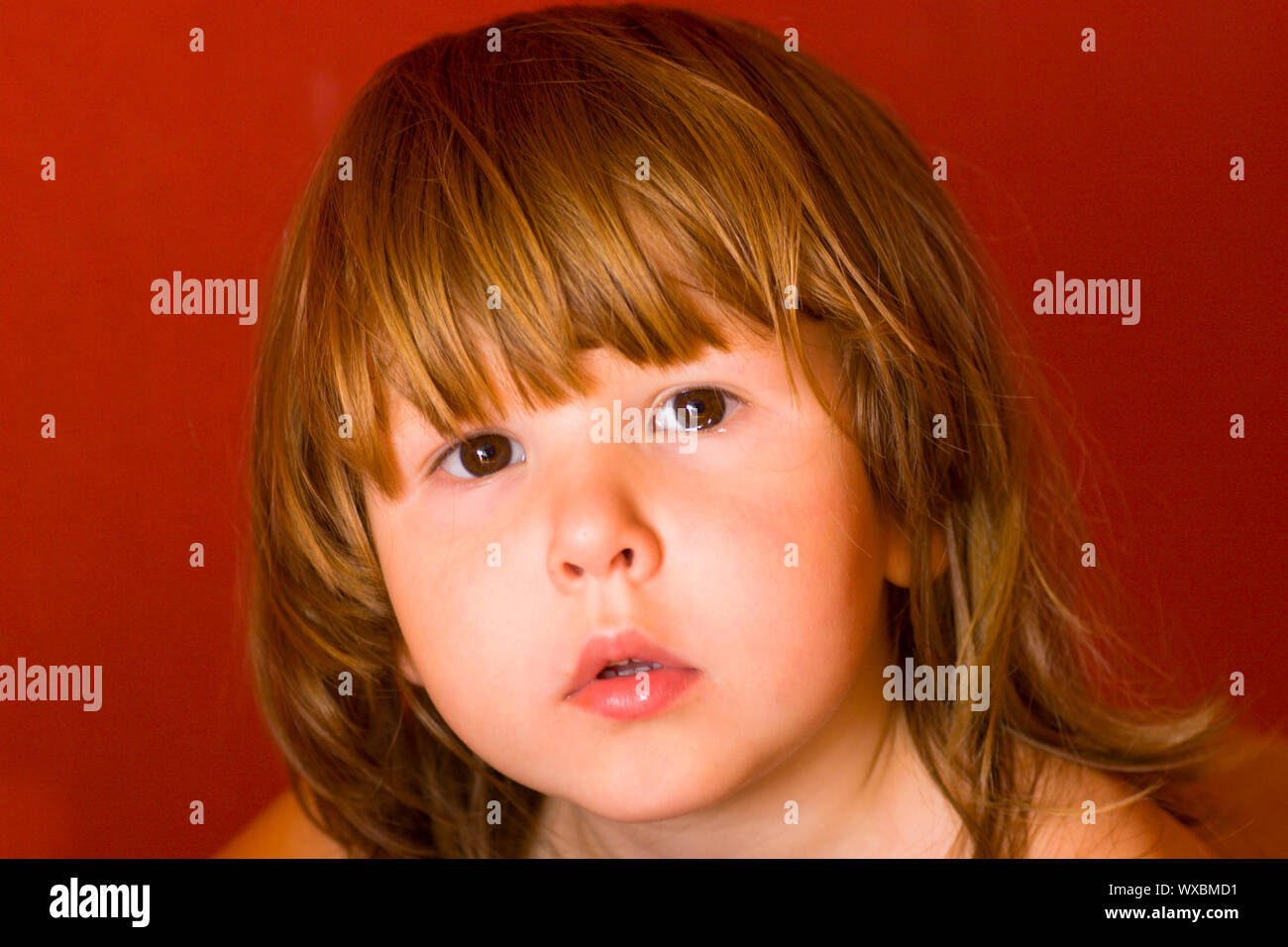 Portrait of little girl looking up at you Stock Photo - Alamy