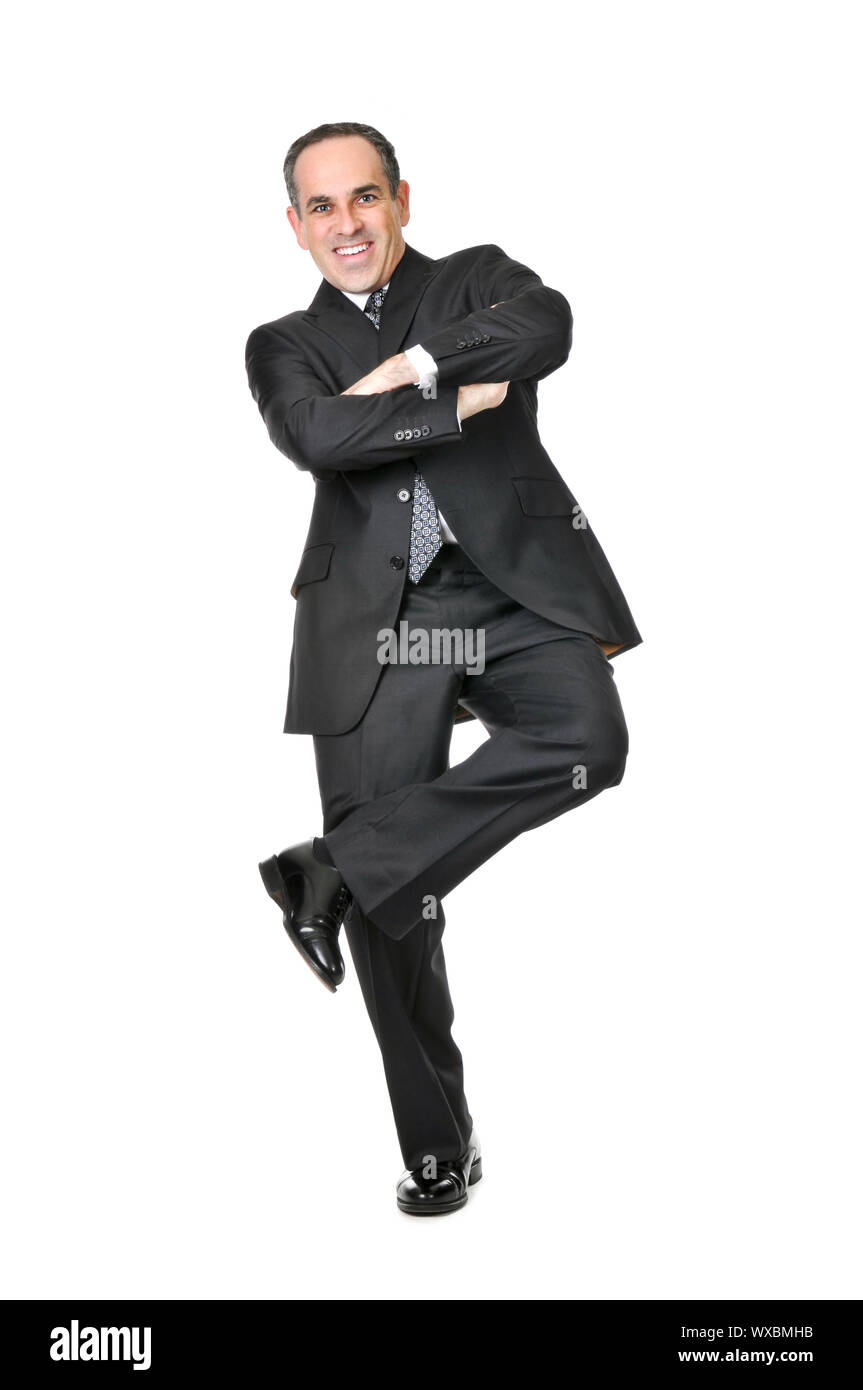 Happy businessman in a suit standing on one leg isolated on white ...