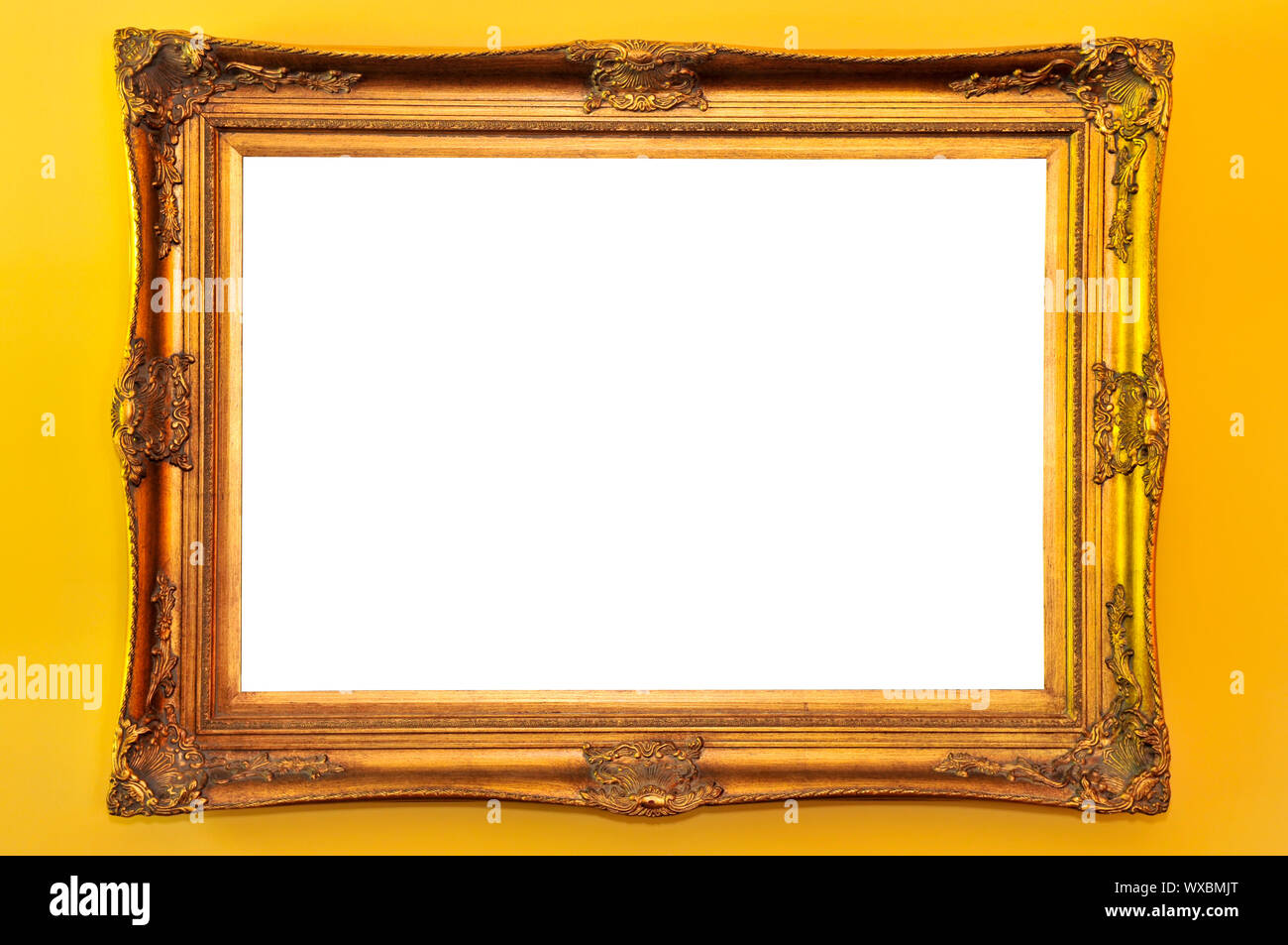 Empty gold picture frame on yellow wall Stock Photo - Alamy