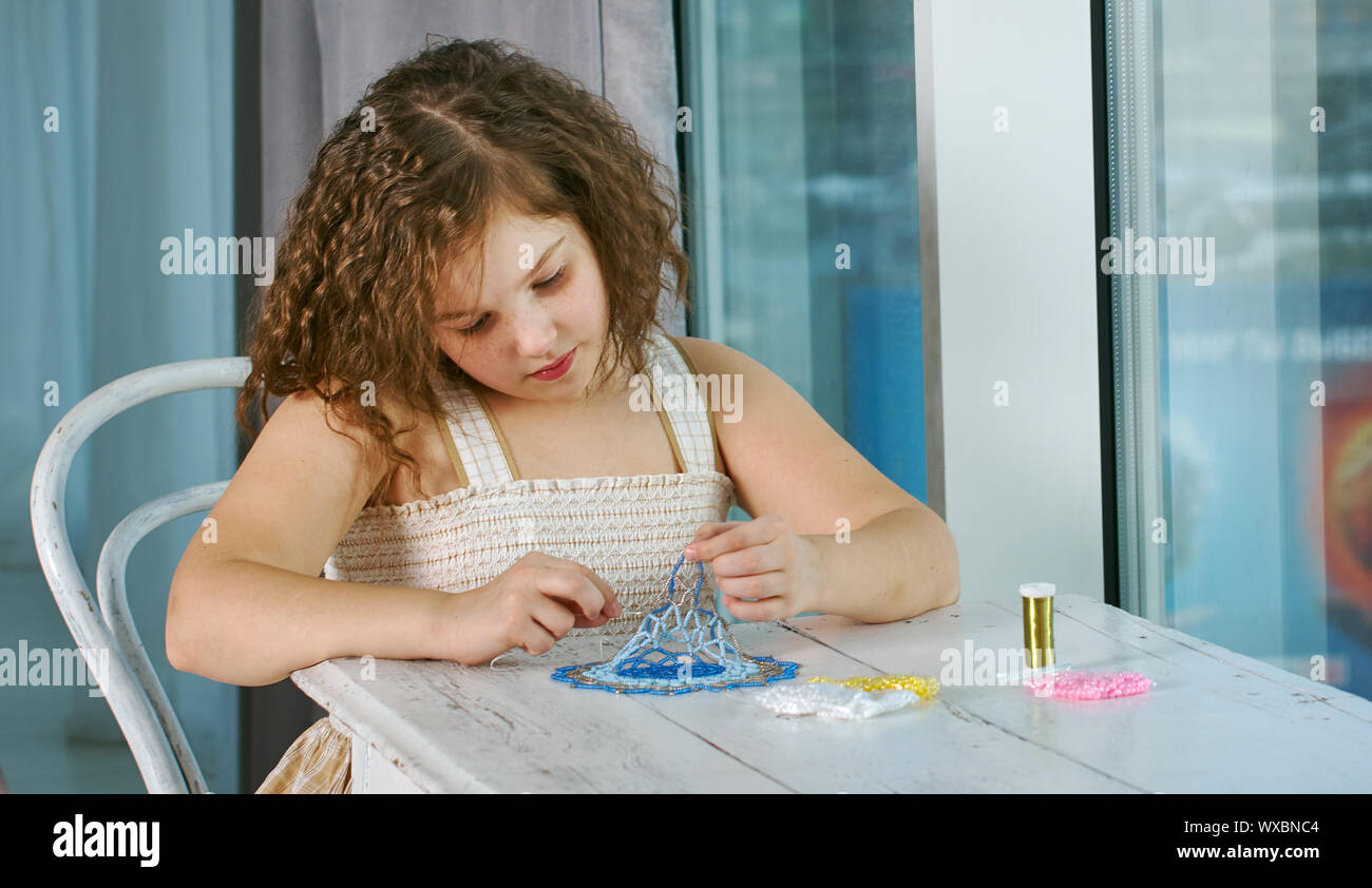 Little girl making jewelry Stock Photo - Alamy
