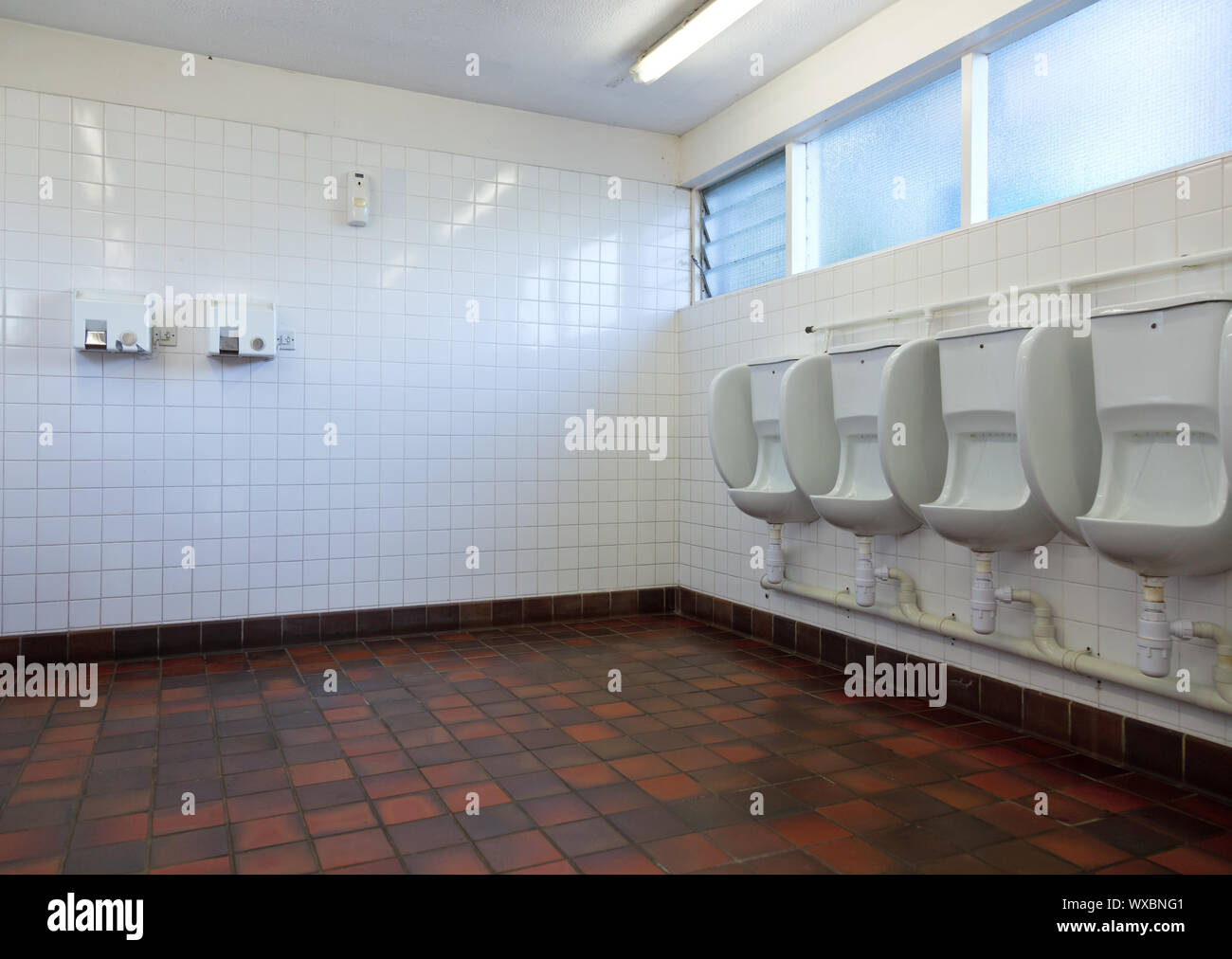 Empty public lavatory with urinals and hand dryers Stock Photo - Alamy