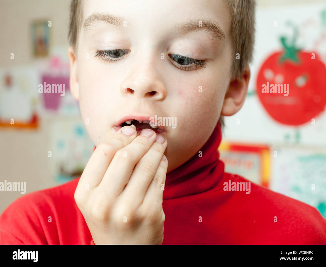 Boy holding lost deciduous teeth against his drawing on the wall Stock ...