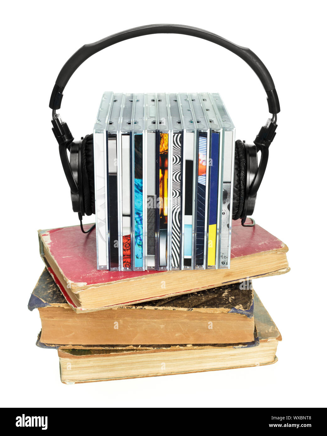 Stack of CDs with HI-Fi headphones and old books on white background ...