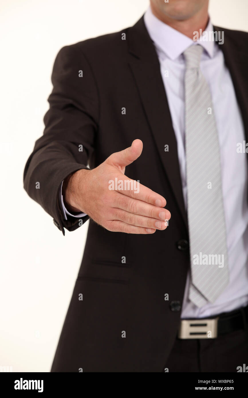 Businessman holding his hand out for a handshake Stock Photo - Alamy