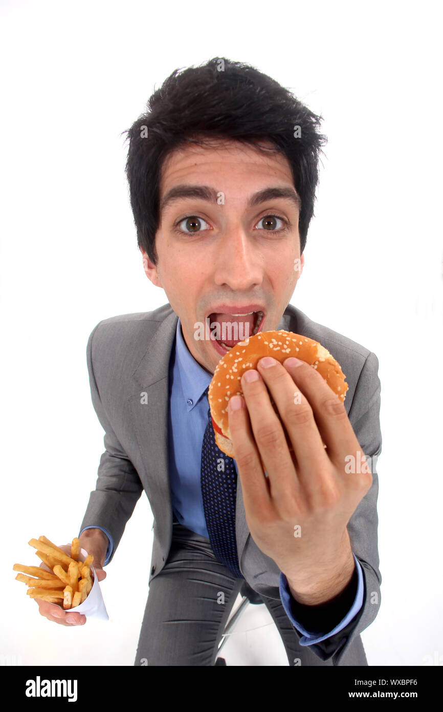 Businessman eating junk food Stock Photo - Alamy