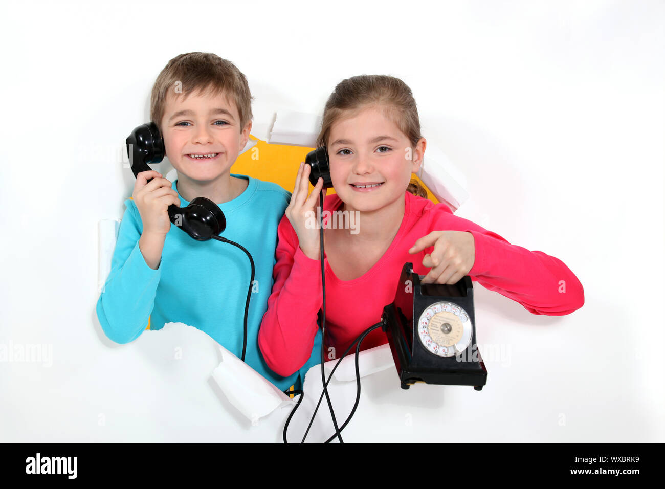 Brother and sister with old-fashioned telephone Stock Photo - Alamy