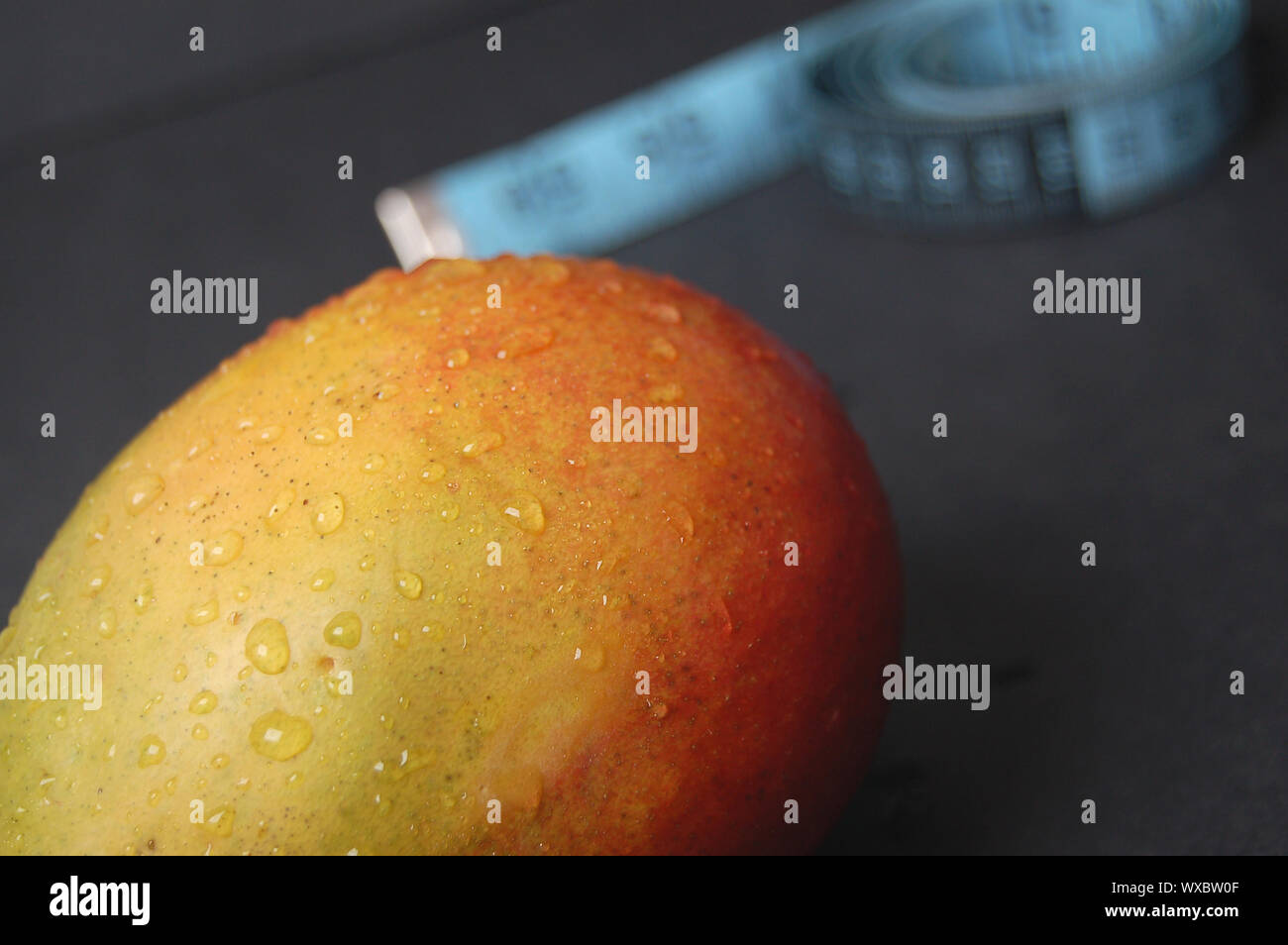 This is an image of a mango and a measuring tape in the background ...