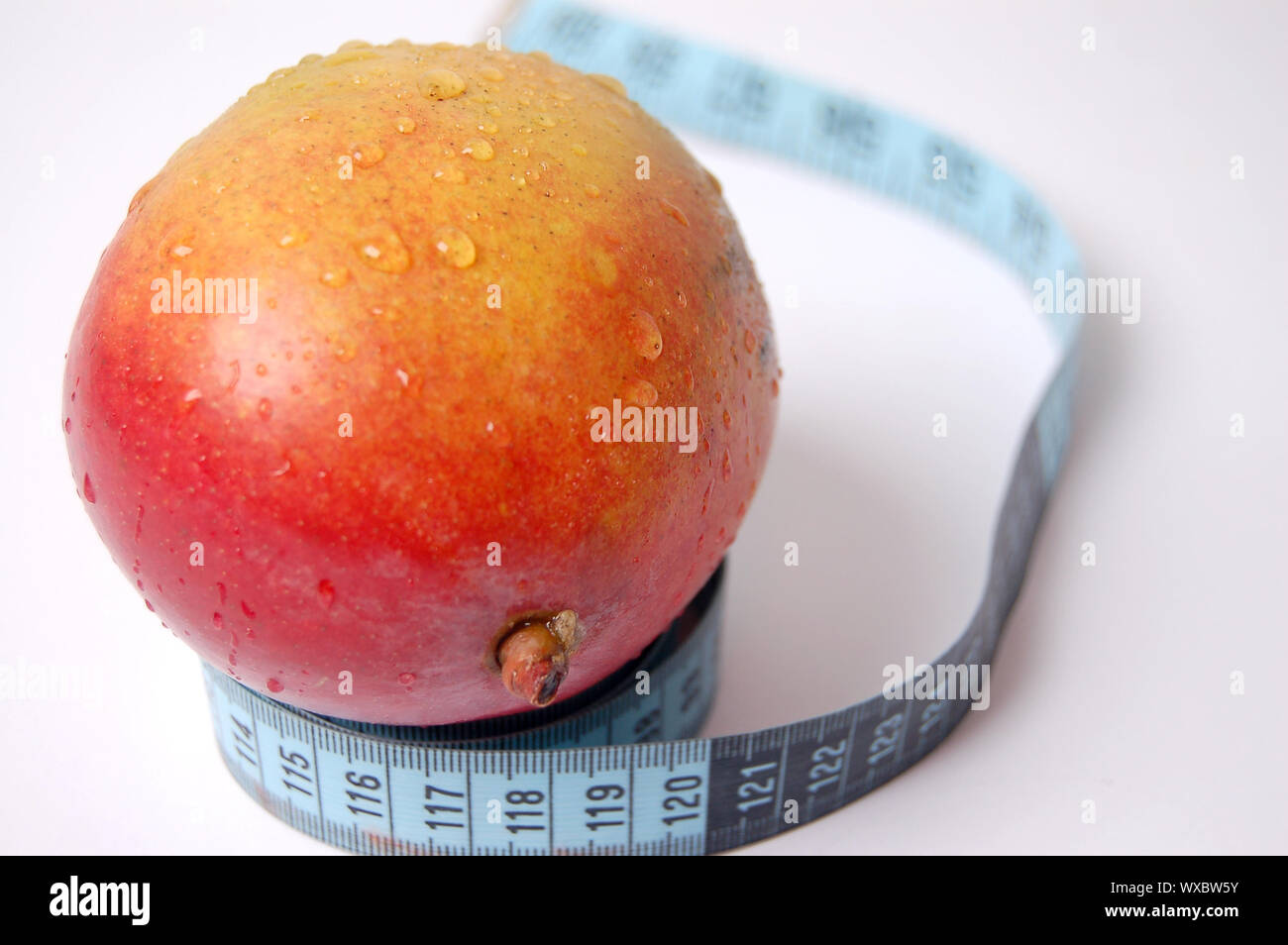 This is an image of mango with a measuring tape Stock Photo - Alamy