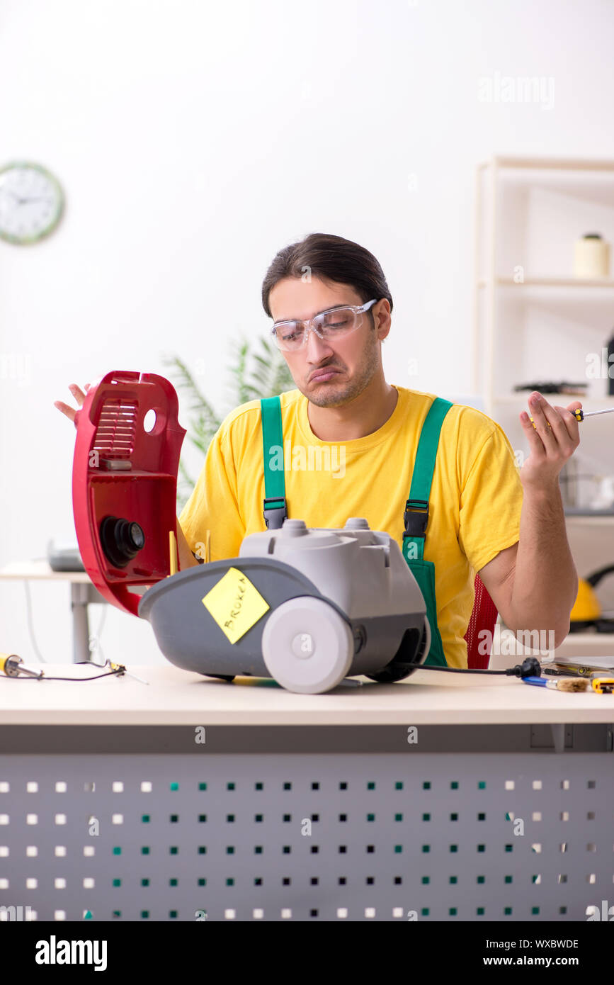 Man repairman repairing vacuum cleaner Stock Photo - Alamy