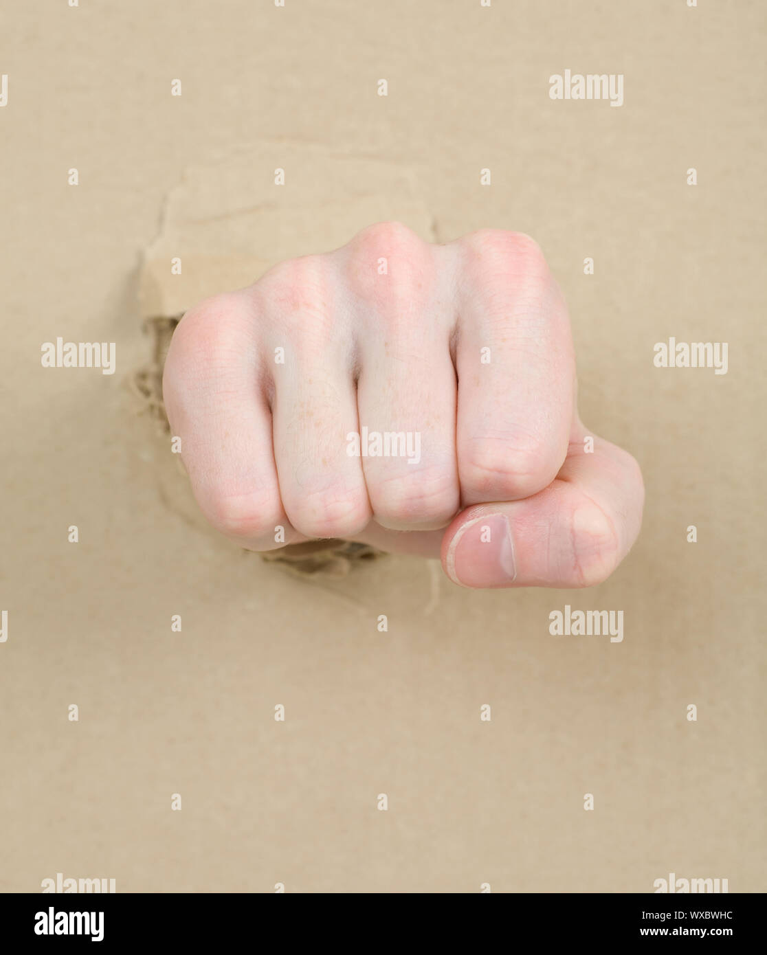 Gesture male hand through from hole in cardboard Stock Photo - Alamy