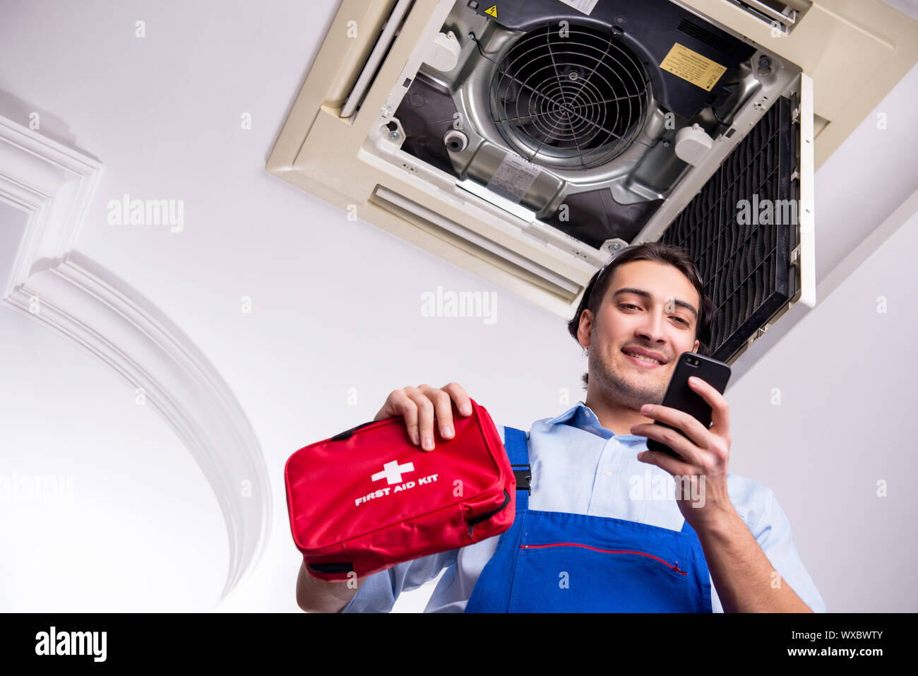 Young repairman repairing ceiling air conditioning unit Stock Photo - Alamy