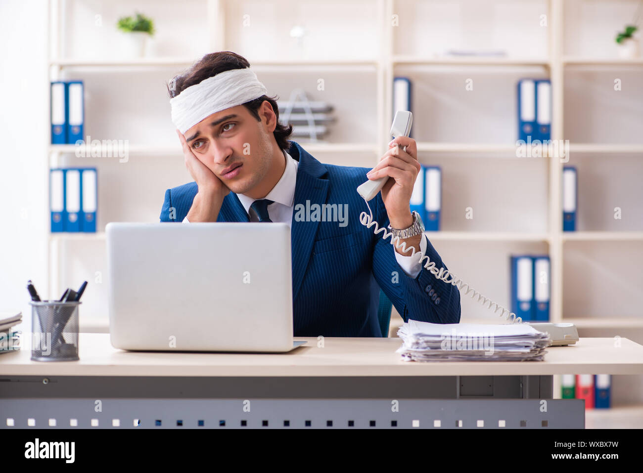Head injured male employee working in the office Stock Photo - Alamy