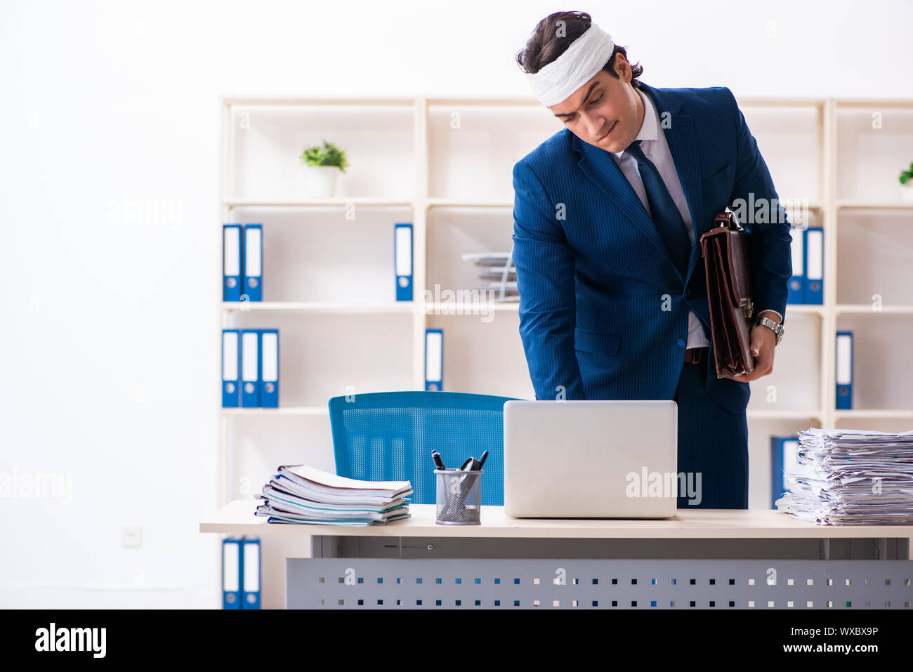 Head injured male employee working in the office Stock Photo - Alamy