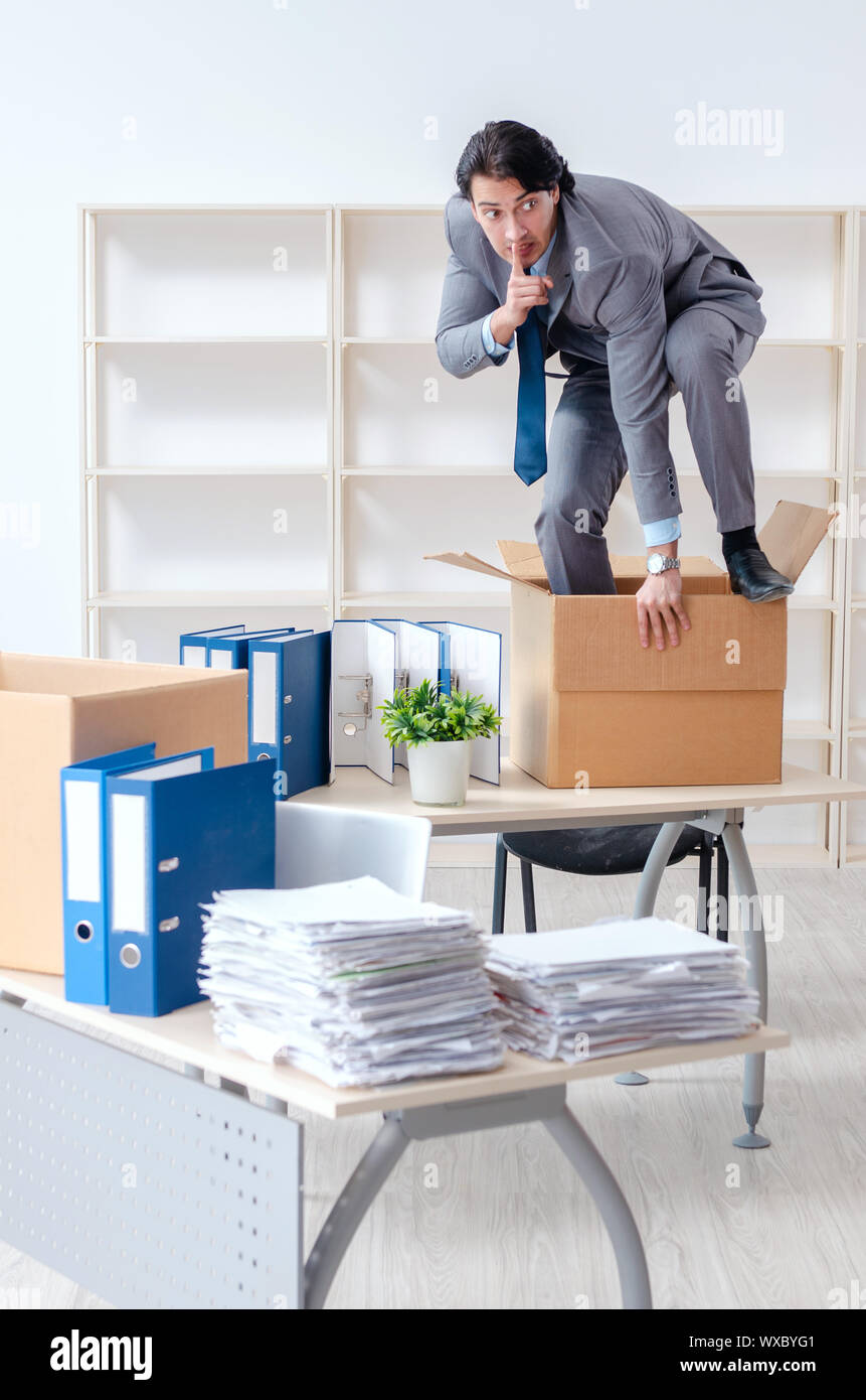 Young man employee with boxes in the office Stock Photo - Alamy