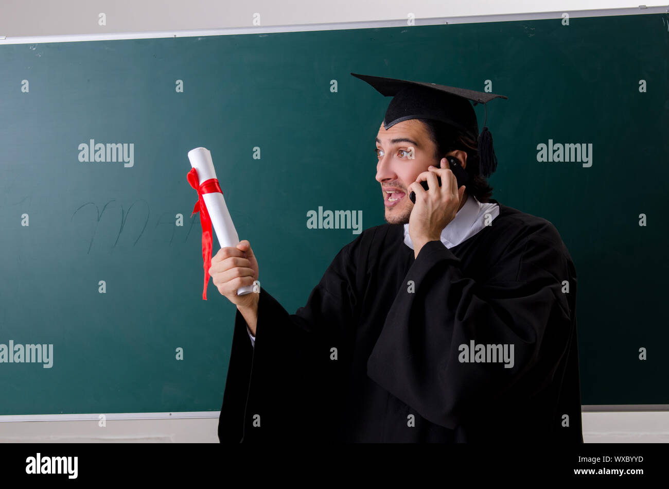 Graduate student in front of green board Stock Photo - Alamy