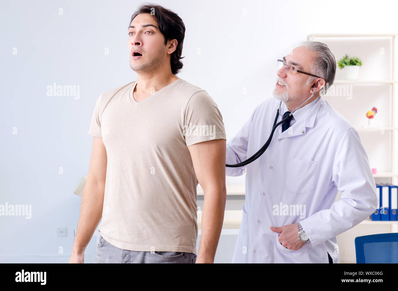 Young male patient visiting old doctor Stock Photo - Alamy