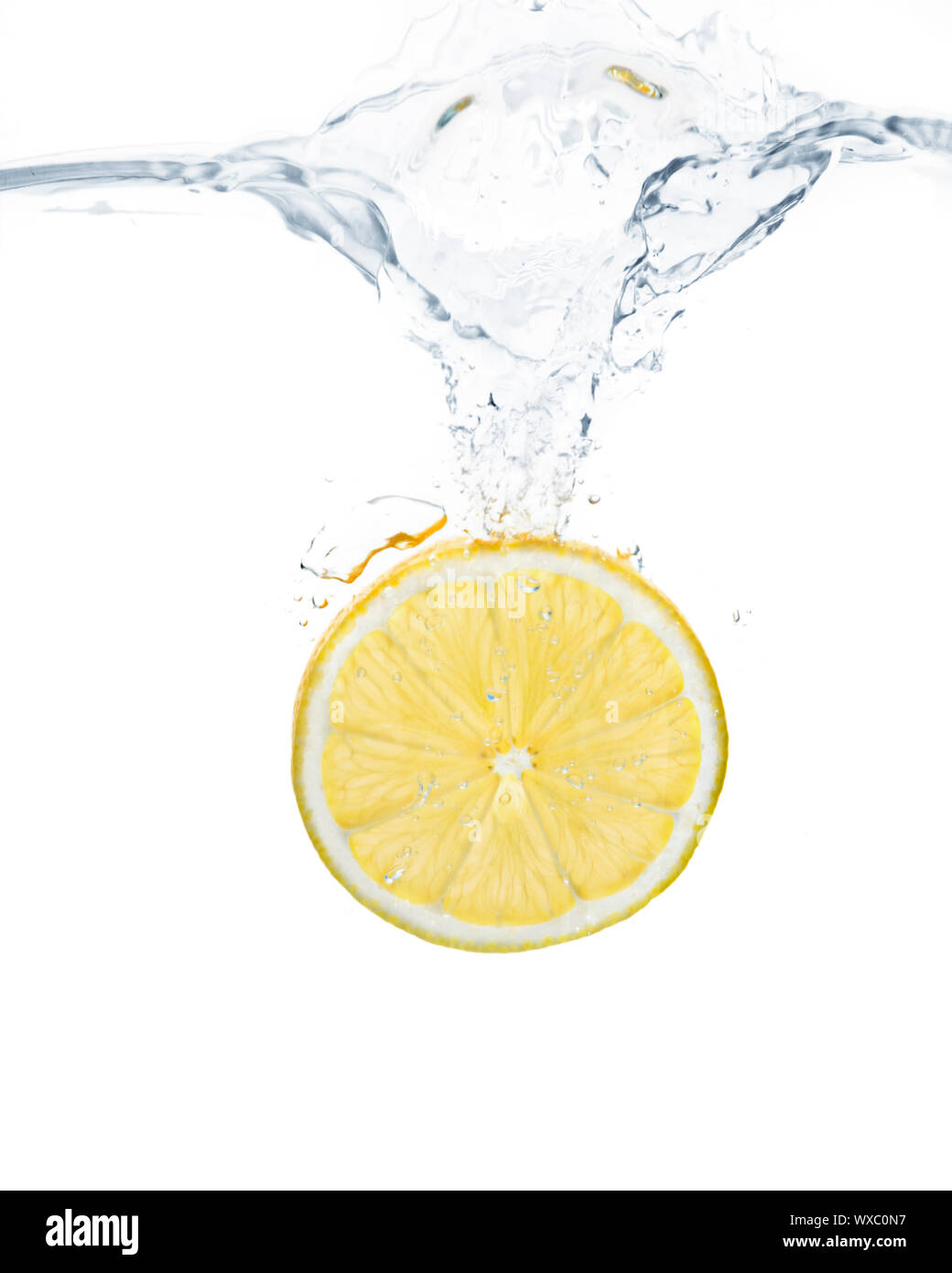 lemon slice splashing into water with white background Stock Photo - Alamy