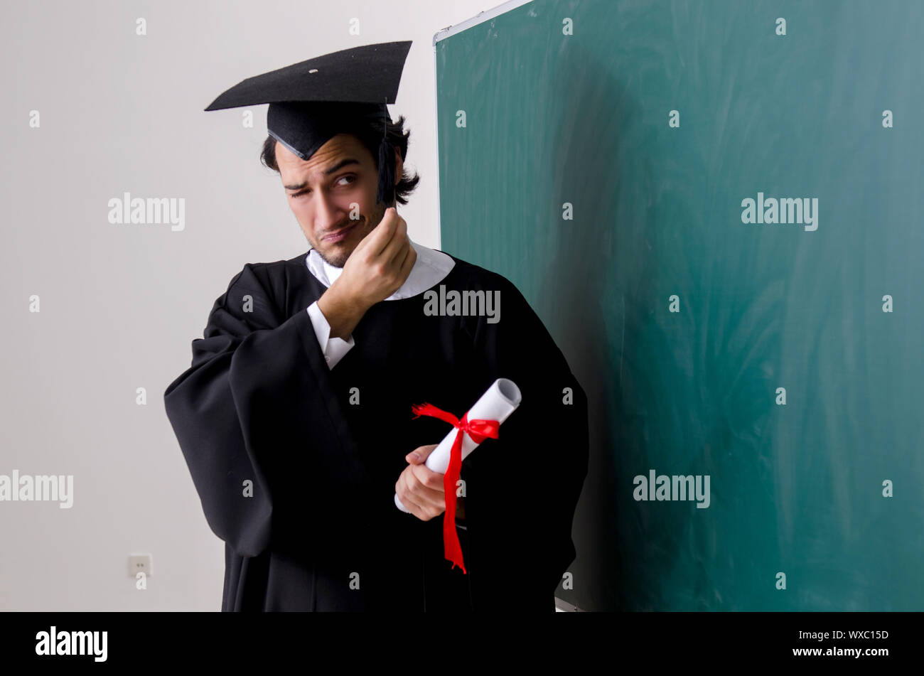 Graduate student in front of green board Stock Photo - Alamy