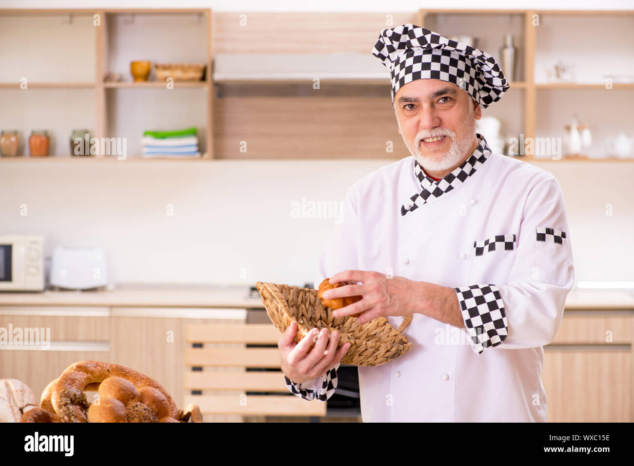 Old male baker working in the kitchen Stock Photo - Alamy