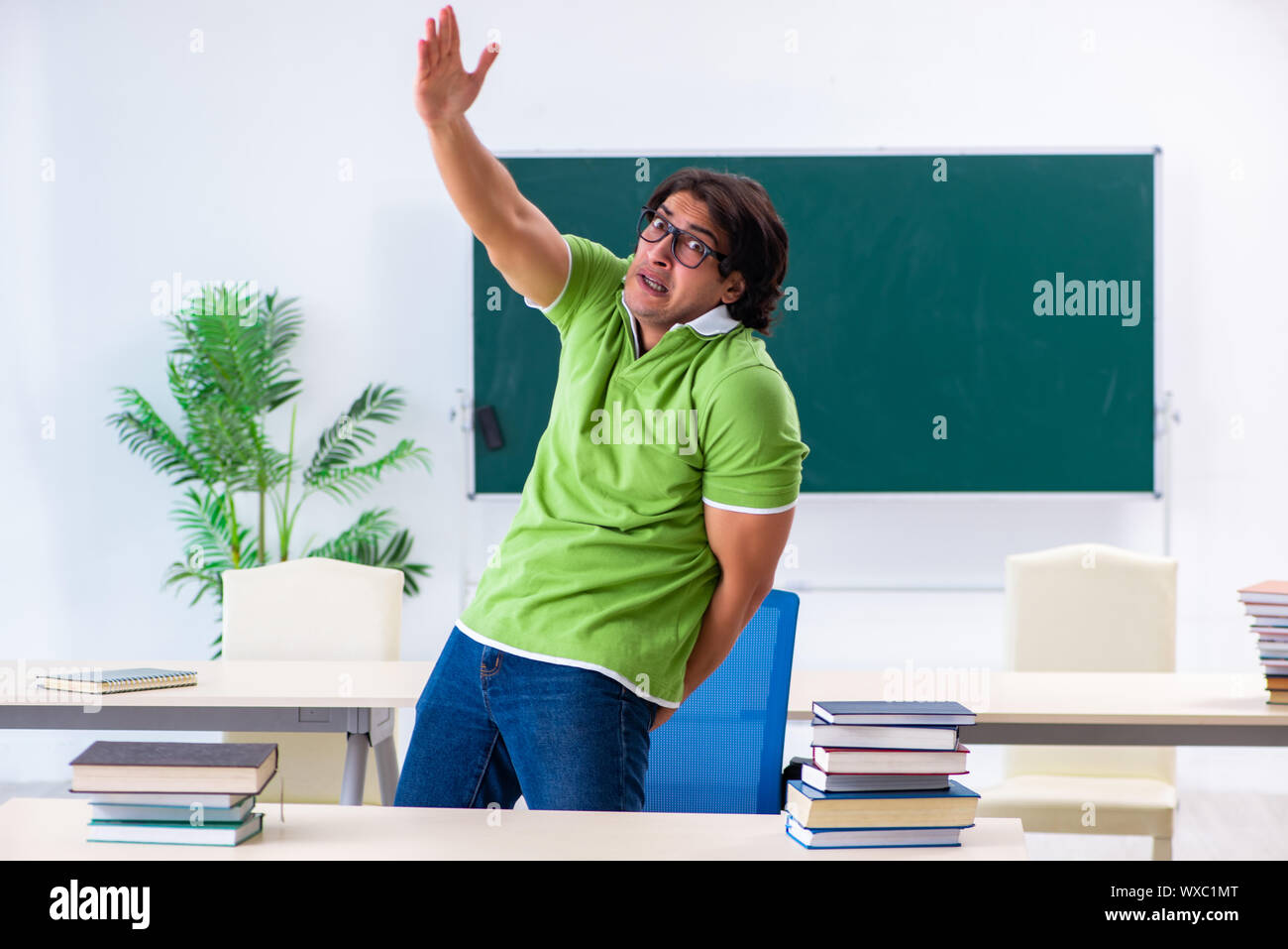Male student suffering from urge in the classroom Stock Photo - Alamy