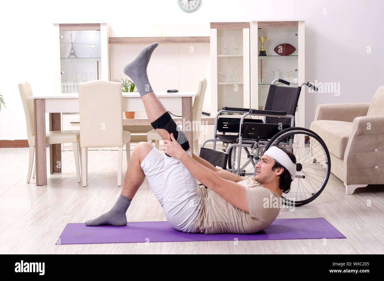 Injured young man doing exercises at home Stock Photo - Alamy