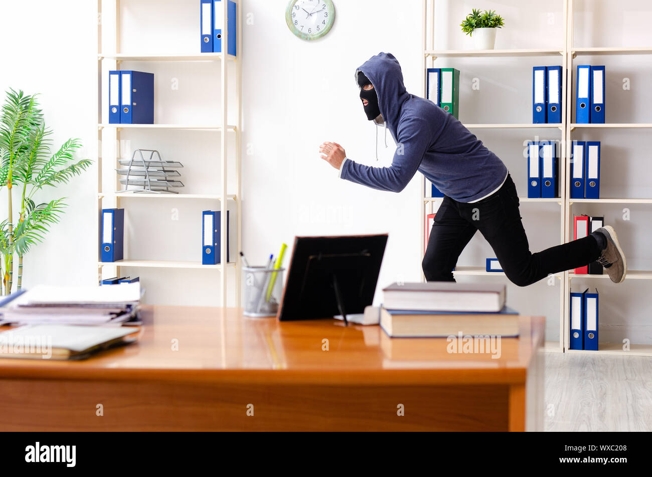 Male thief in balaclava in the office Stock Photo - Alamy